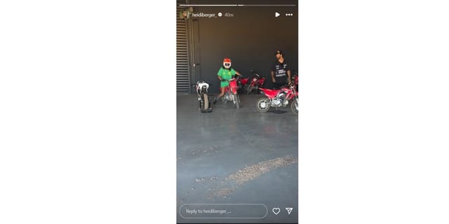Daniel Ricciardo looks on as partner Heidi Berger rides a motocross bike