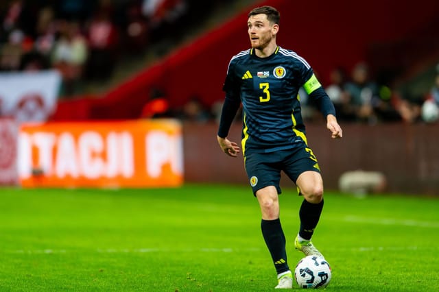 Andy Robertson points at captain's armband and appears to shout at ...